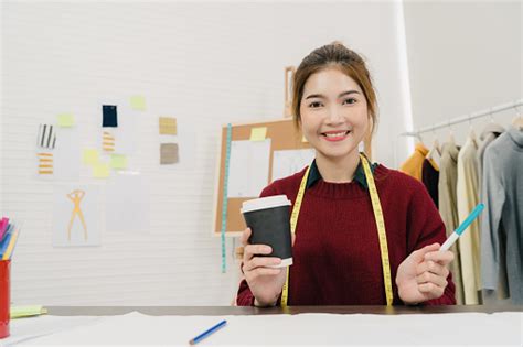 직업적인 아름 다운 아시아 여성 패션 디자이너 직물 스케치와 함께 작업 하 고 스튜디오에서 의류 디자인을 그리기 라이프 스타일