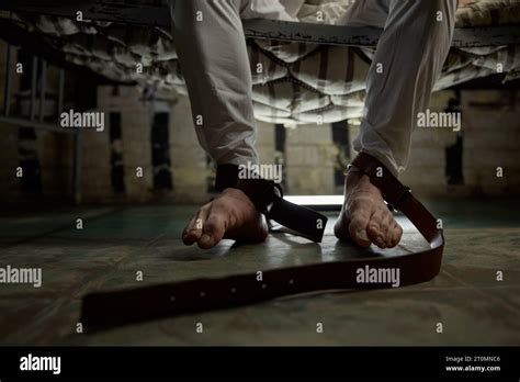 Closeup Barefoot Legs Of Psycho Man Bound With Tight Brown Belt Stock