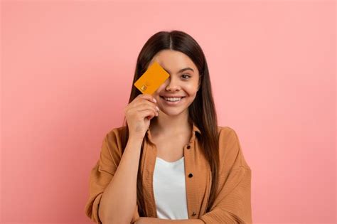 Premium Photo Happy Teenage Girl Holding Credit Card Covering Eye And