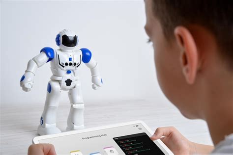 Premium Photo Boy Controls Robot Using Tablet On Desk Illustrating