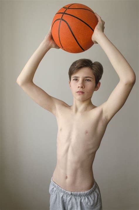 Muchacho Del Adolescente En Una Camisa Blanca Con Una Bola Para El Voleibol Foto De Archivo