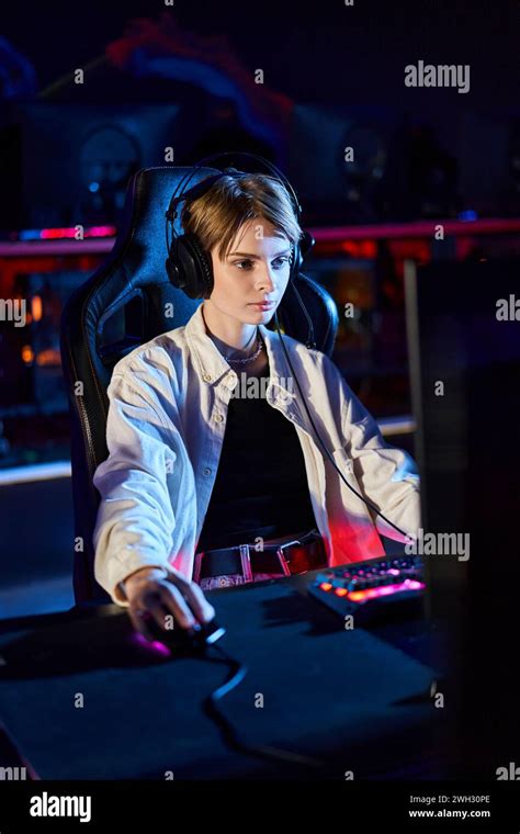 Female Gamer In Headphones Looking At Computer Monitor While Thinking