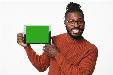 하얀 배경에 고립 된 카피 스페이스 여유 공간을위한 녹색 모형으로 디지털 태블릿 화면을 보여주는 행복한 미소를 짓는 젊은 아프리카 계 미국인 남자 35 39세에 대한 스톡