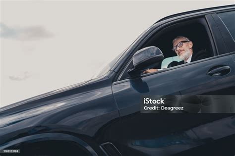 정장을 입은 고위 사업가가 여행과 성공을 상징하는 도시 거리에서 고급 자동차를 운전합니다 50 54세에 대한 스톡 사진 및 기타 이미지 50 54세 거리 교통수단