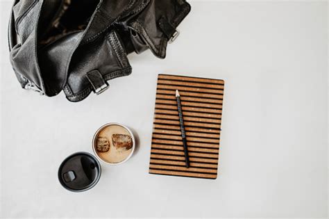 가 서 아이스 커피입니다 우유 부 어 보온병에 커피 얼음 큐브를 동결 연필로 여자 핸드백 및 참고도 서의 플랫 하다 흰색 배경 고립 된 공간을 복사 합니다 단열 음료 용기에