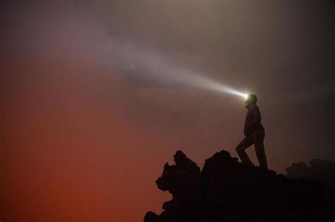 Premium Photo Woman With Head Torch Standing Against Orange Sky