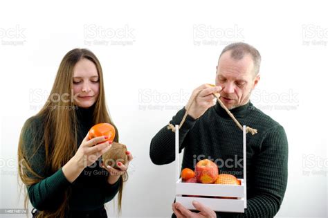 손에 과일 상자의 형태로 바구니를 들고 남자 젊은 여자는 그리드 사과와 감귤 맛있는 건강 식품 열대 국가 건강 식품 과일