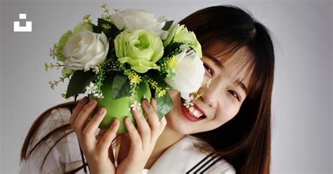 흰 장미 꽃다발을 들고 있는 흰색 긴 소매 셔츠를 입은 여자 사진 Unsplash의 무료 꽃 이미지