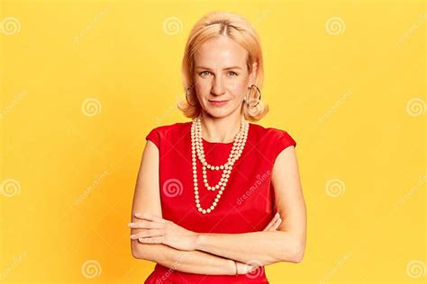 Portrait Of Blond Woman Wearing Red Dress Looking At Camera With Folded