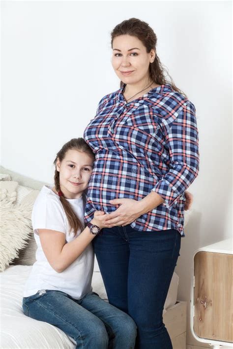 Gravid Moder Med Den Nakna Magen Som Sitter På Sängen Med Hennes