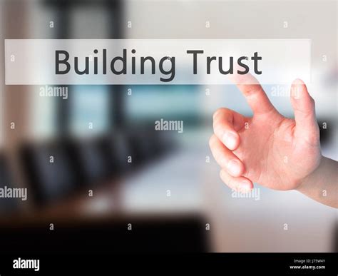 Building Trust - Hand pressing a button on blurred background concept . Business, technology ...