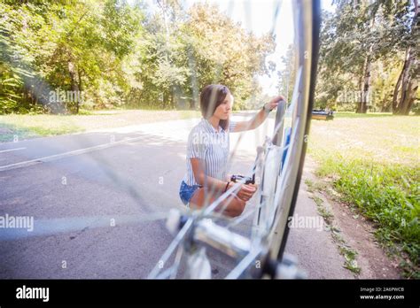 Young Woman Checking Her Bicycle She Riding Bike In The Park On Summer
