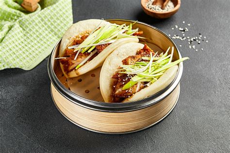 호이신 치킨을 곁들인 바오 빵 어두운 슬레이트 테이블에 대나무 증기선을 중국어 아시아 정통 식품 개념 Baozi에 대한 스톡