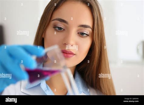 Female Scientist Pour Pink Liquid From Flask In Medical Chemistry Lab Stock Photo Alamy