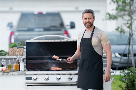 Premium Photo Grill And Barbecue Cook Chef With Bbq Cooking Tools