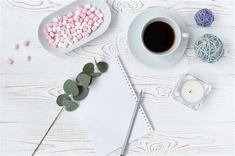 흰색 테이블 위에 커피 머그잔 마시멜로 빈 노트북 연필과 꽃의 상단보기 여자 작업 책상입니다 0명에 대한 스톡 사진 및 기타