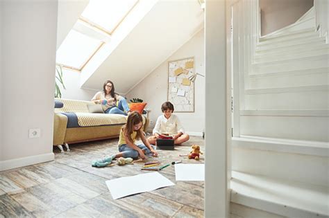 가정에서 함께 시간을 보내는 가족 아이들은 바닥에 앉아 소파에서 노트북을 들고 노는 동안 놀고 있습니다 십대 소년 과 숙제