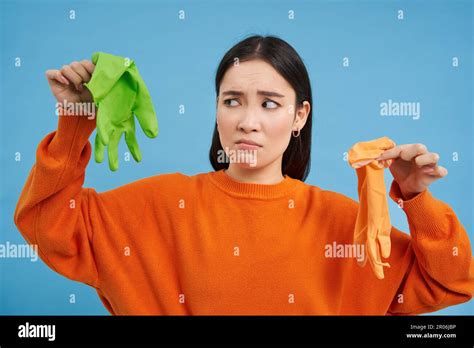 Portrait Of Sad Korean Woman Showing Two Latex Gloves With Upset Face
