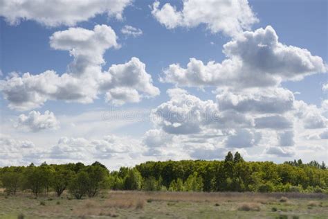 Bright Early Spring Landscape With Fluffy Clouds In Blue Sky With