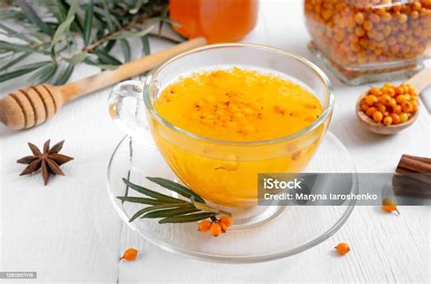 유리 컵에 화려한 뜨거운 천연 바다 갈매 나무 속 차 신선한 생 딸기와 잎 꿀 아니스와 계피 스틱 비타민 건강 의학 음료 따뜻한 제철 음료의 개념 0명에 대한 스톡 사진 및