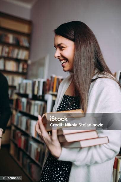 Dua Siswa Perempuan Membaca Dan Belajar Di Rak Buku Di Perpustakaan