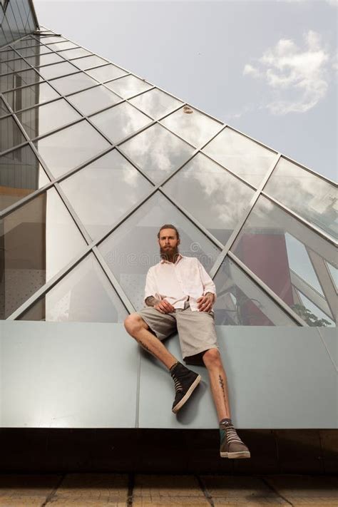 Bearded Tattooed Hipster Posing In Front Of Office Building Stock Image