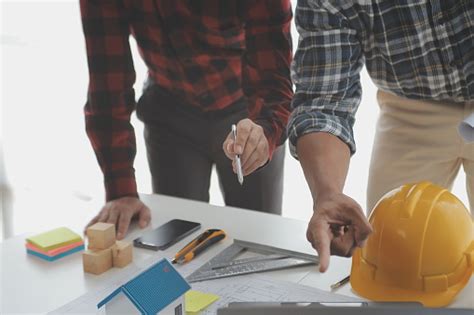 엔지니어 또는 건축가의 건설 및 구조 개념은 작업 현장의 모델 구축 및 청사진에 대한 파트너 및 엔지니어링 도구와 함께 작업하는 프로젝트를 위해 회의 두 회사의 계약 2명에