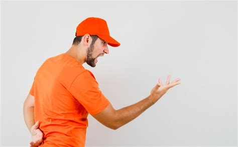 Free Photo Delivery Man In Orange T Shirt Cap Making Asking Question