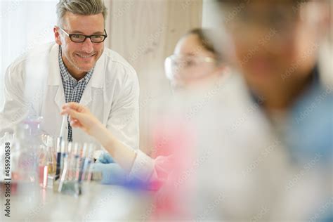 Male Teacher And Girl Babes Conducting Scientific Experiment In Laboratory Classroom Stock