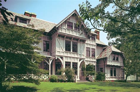 A Large White House Sitting On Top Of A Lush Green Field