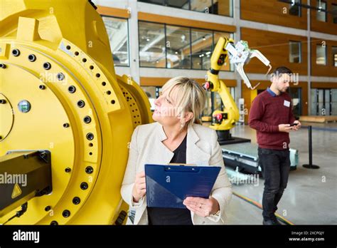 Engineers Conducting Inspections And Programming Robotic Machinery In An Advanced Industrial