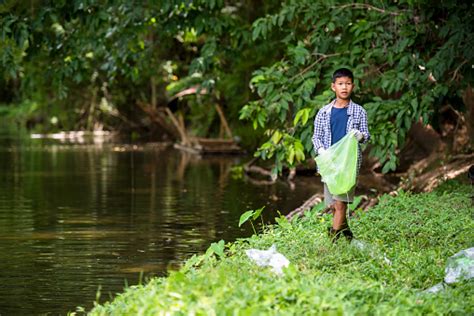 그룹 학생 자선 단체 및 환경을위한 플라스틱을 재활용하십시오 사람들은 자연을 지키기 위해 쓰레기와 플라스틱을 자연 강에서 수거하기 위해 쓰레기와 플라스틱을 모으는 소년