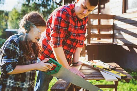 아버지는 도구를 사용 하는 아이 딸을 가르치고 여름에 야외 건물 작업으로 아빠를 돕는 소녀 배경에 컨트리 하우스 가족에 대한 스톡 사진 및 기타 이미지 Istock