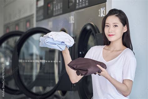 Foto De 셀프 서비스 세탁실에서 세탁기와 건조기 배경으로 손위에 옷감을 올린 젊은 아시아 한국 여자 모델 Do Stock Adobe Stock