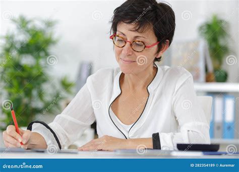 Focused Casual Female Architect Working At Drawing Board Stock Image