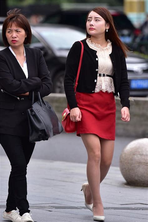 路人街拍黑外套红短裙的微胖美女杏脸桃腮笑靥如花