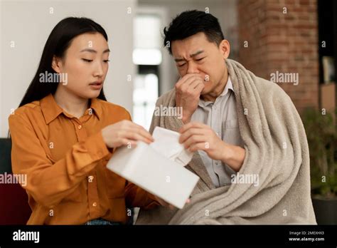 Loving Asian Woman Taking Care Of Sick Husband Wife Giving Nupkins To