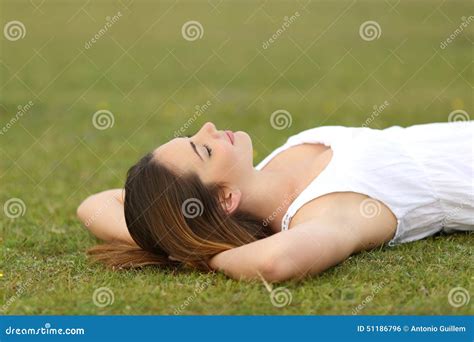 Relaxed Woman Lying On The Grass Sleeping In A Tranquil Scene Stock