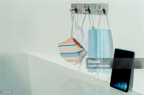 코로나 바이러스 동안 휴대 전화에 추적 응용 프로그램에 문의 휴대 전화 기술 장치 개념으로 집에 매달려 있는 얼굴 마스크 외과 의료 커버및 직물 수제 마스크 접촉자 추적에