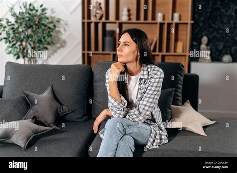 Pensive Calm Caucasian Brunette Woman Dressed In Stylish Casual Clothes Sits Alone On A