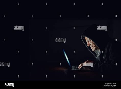 You Wont Even See Him Coming A Hooded Computer Hacker Using A Laptop