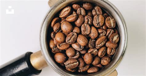 흰색 세라믹 머그잔에 갈색 커피 콩 사진 Unsplash의 무료 커피 이미지