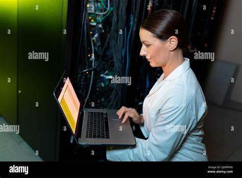 Caucasian Female Engineer Wearing An Apron Using Laptop While