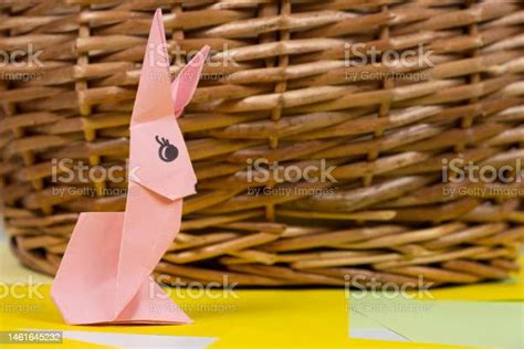 종이로 만든 부활절 토끼의 그림 고리 버들 바구니 근처에 앉아있는 종이 접기 공예품 텍스트를위한 공간 4월에 대한 스톡 사진 및