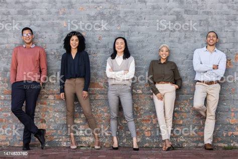 초상화 협업 및 목표는 벽돌 벽에 기대어 함께 서 있는 비즈니스 팀입니다 미래의 성공을 위해 외부의 남녀 직원 그룹과의 팀워크 사고 방식 및 비전 기대기에 대한 스톡 사진