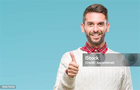 잘생긴 젊은이 행복 엄지손가락 손으로 제스처를 하 고 격리 된 배경 위에 겨울 스웨터를 입고 승인 성공을 보여주는 카메라를 보고 하는 식 가을에 대한 스톡 사진 및 기타