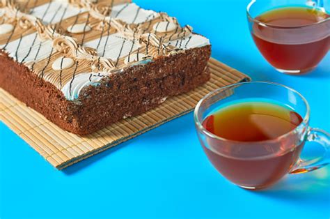 차 두 잔 근처의 체크 무늬 직사각형 케이크 한 개가 파티의 파란색 테이블에 놓여 있습니다 축 하 개념입니다 클로즈업 가득 찬에 대한 스톡 사진 및 기타 이미지 Istock