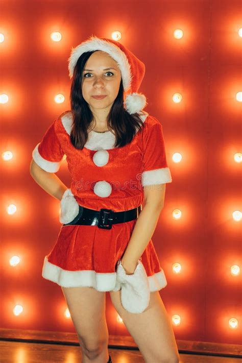 Portrait Of Beautiful Girl Wearing Santa Claus Clothes On Red