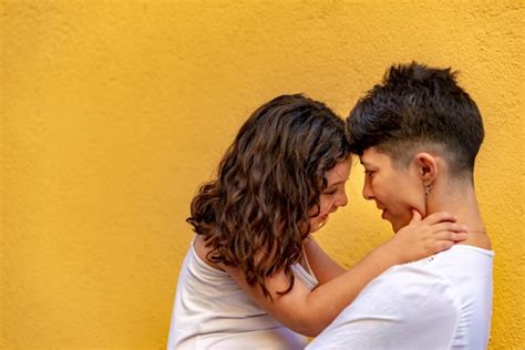 Premium Photo Side View Of Couple Kissing Against Orange Wall
