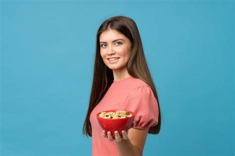 Premium Photo Young Woman Over Isolated Blue Holding A Bowl Of Cereals